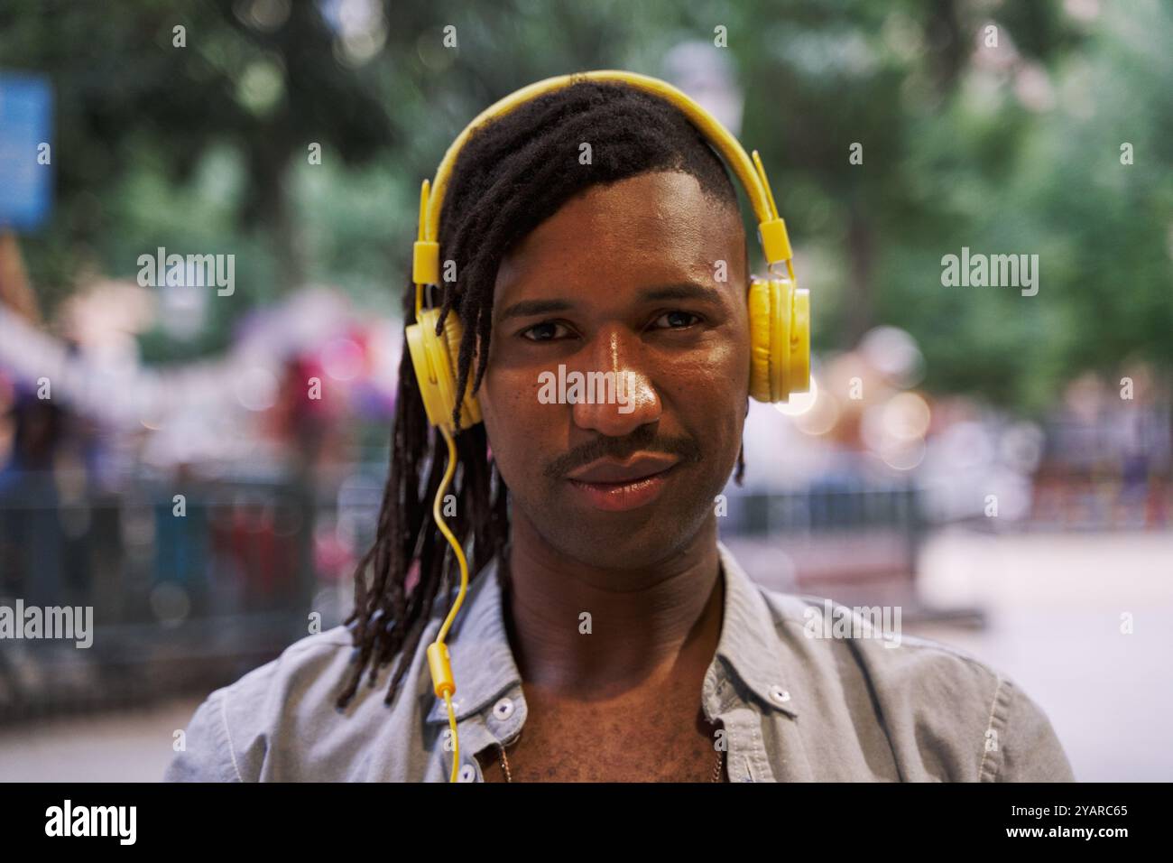 caribbean man listening to music with yellow headphones looking at ...