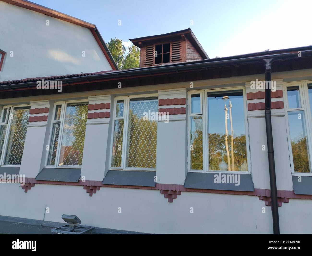 An old building with striking red brick pillars and a pitched roof ...