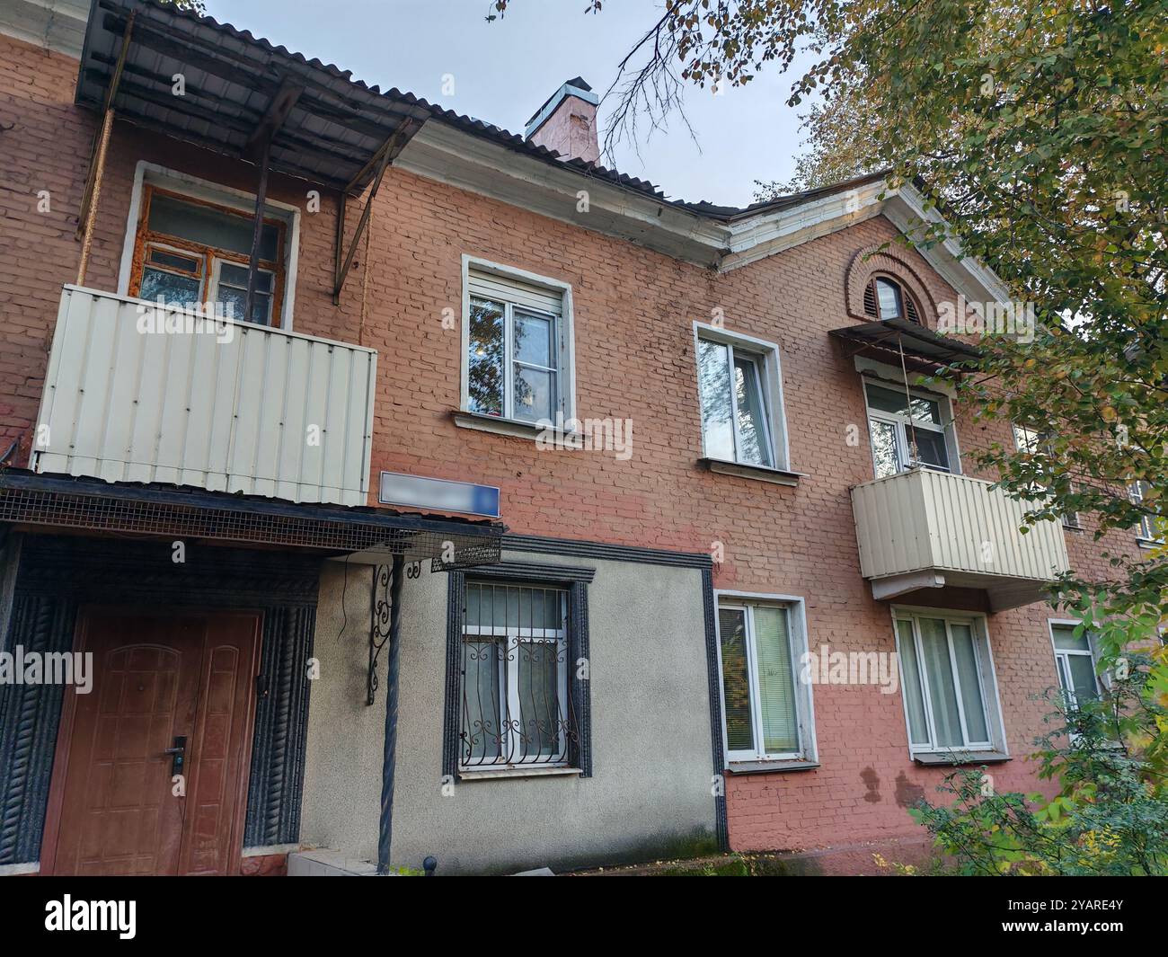 A modest residential building made of red brick, with balconies and a ...