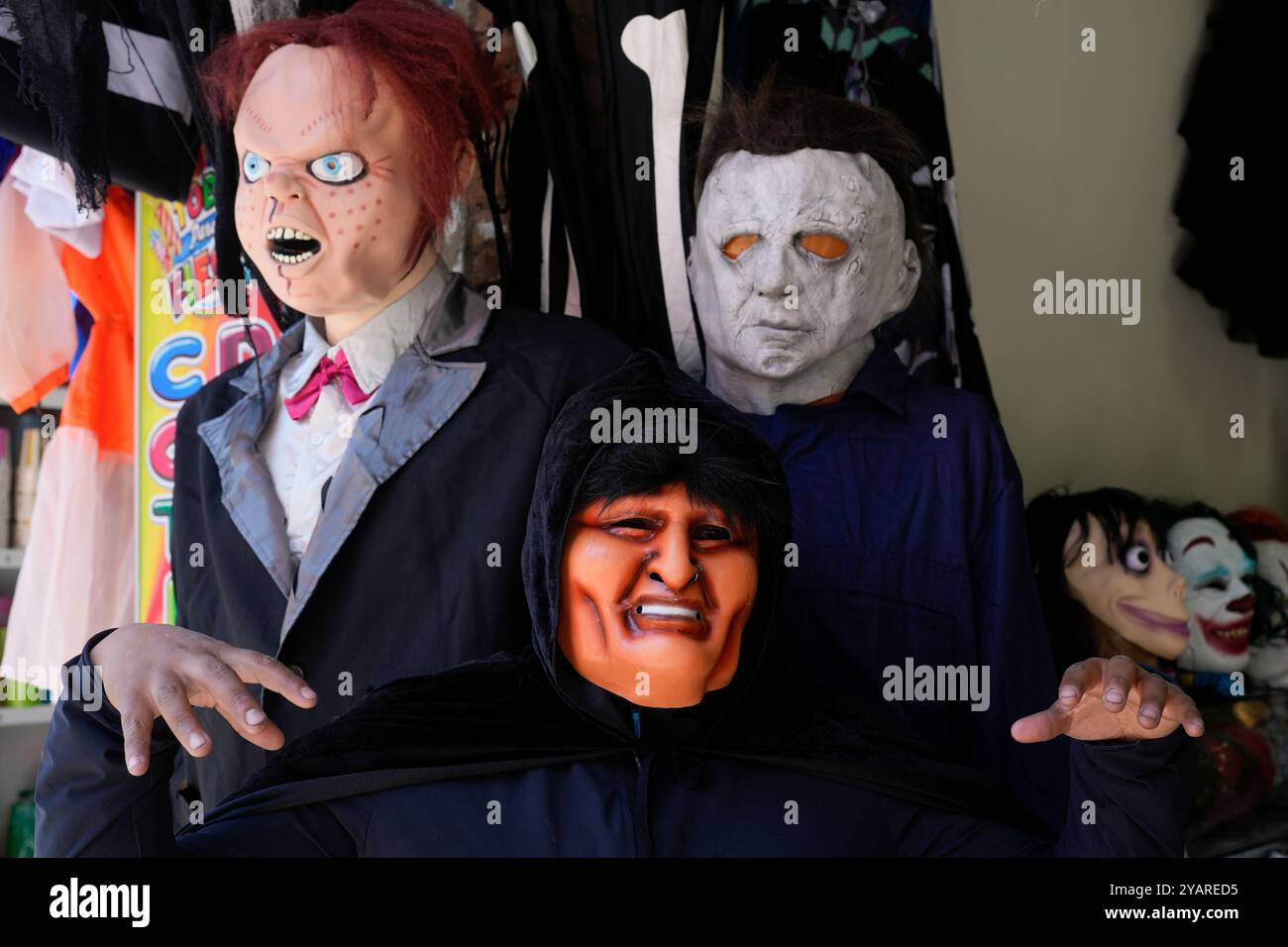 A mask vendor poses for a photo wearing a Halloween mask of former ...