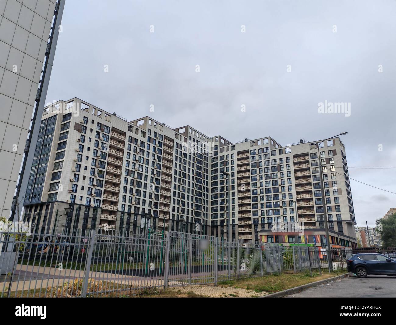 A pastel-colored high-rise residential building with curved balconies ...