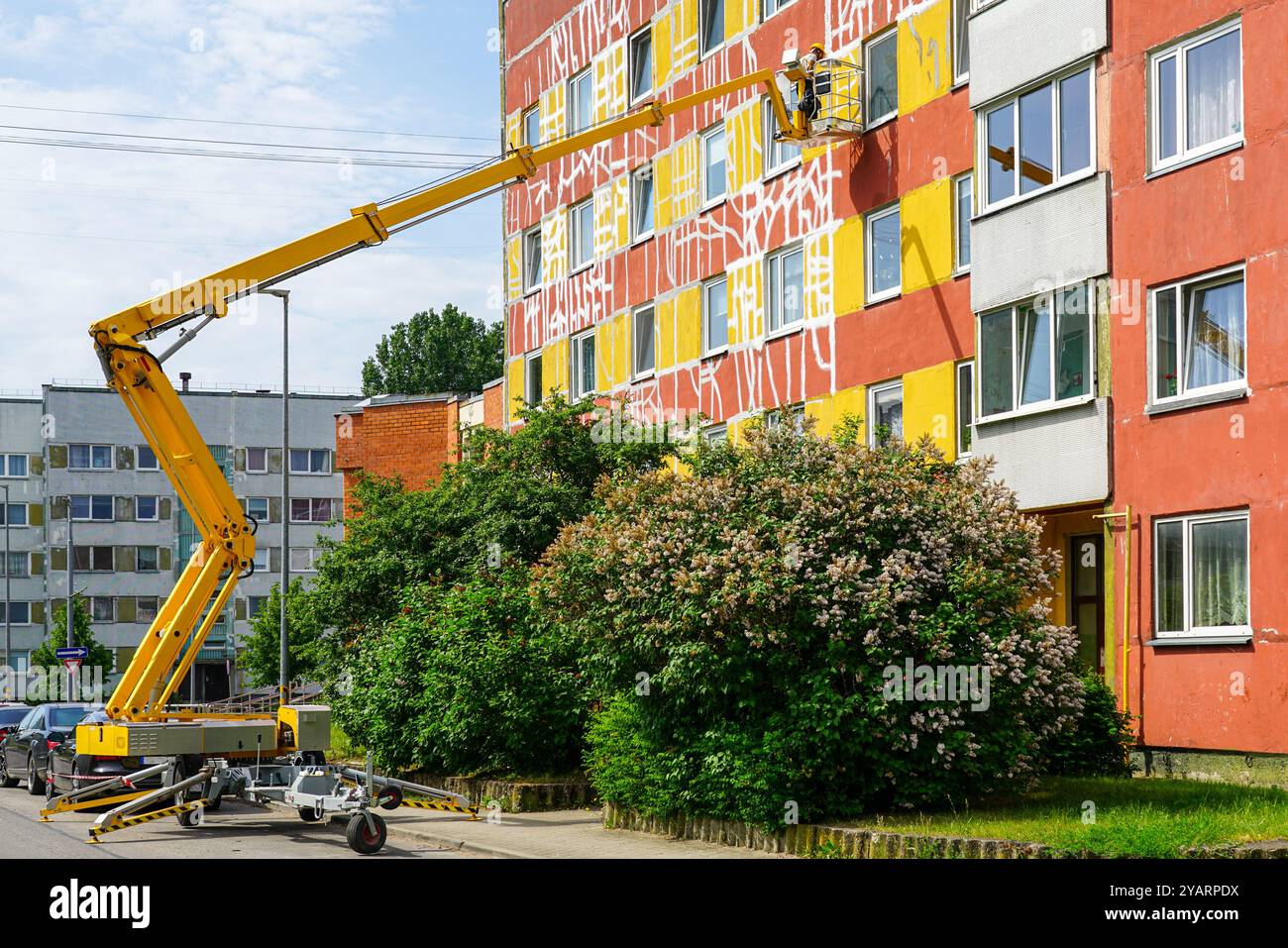Apartment house facade maintenance works using modern self propelled ...