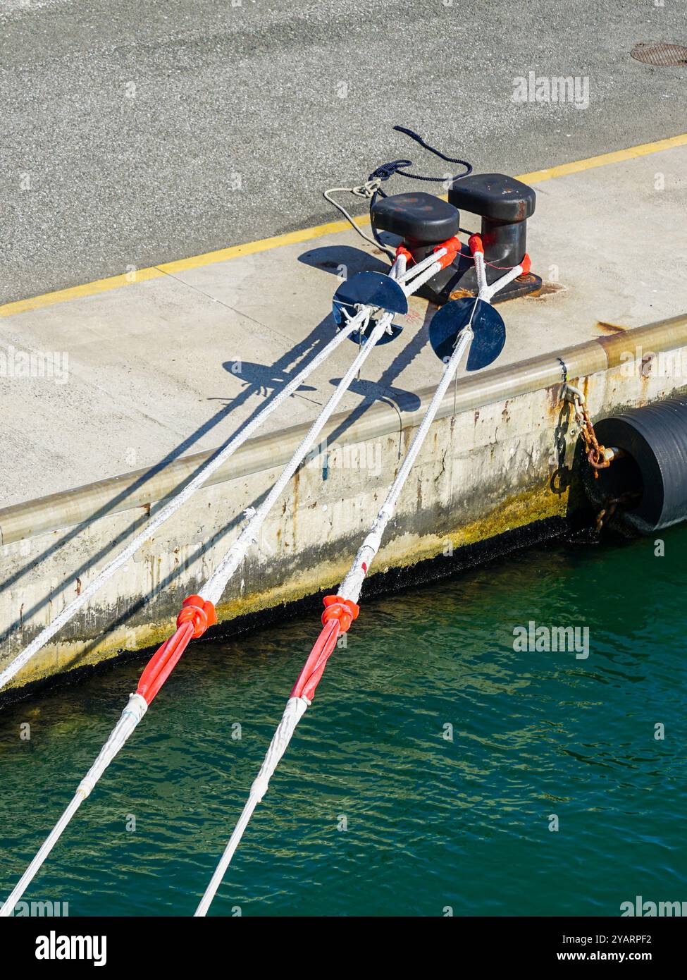 A tense stretched ship's thick mooring ropes at the mooring pole of the ...