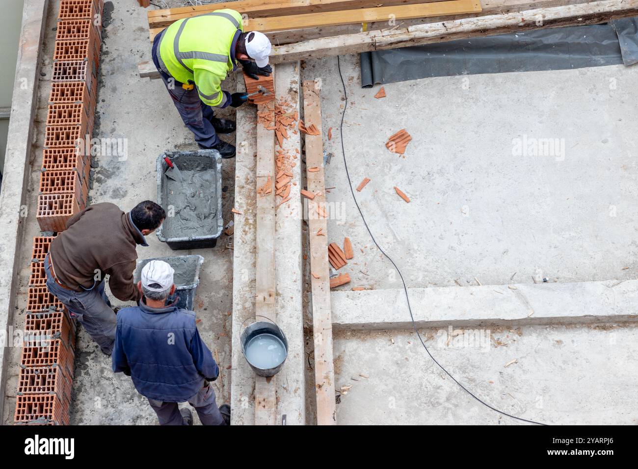 Construction workers prepare cement and mortar for building brick walls ...