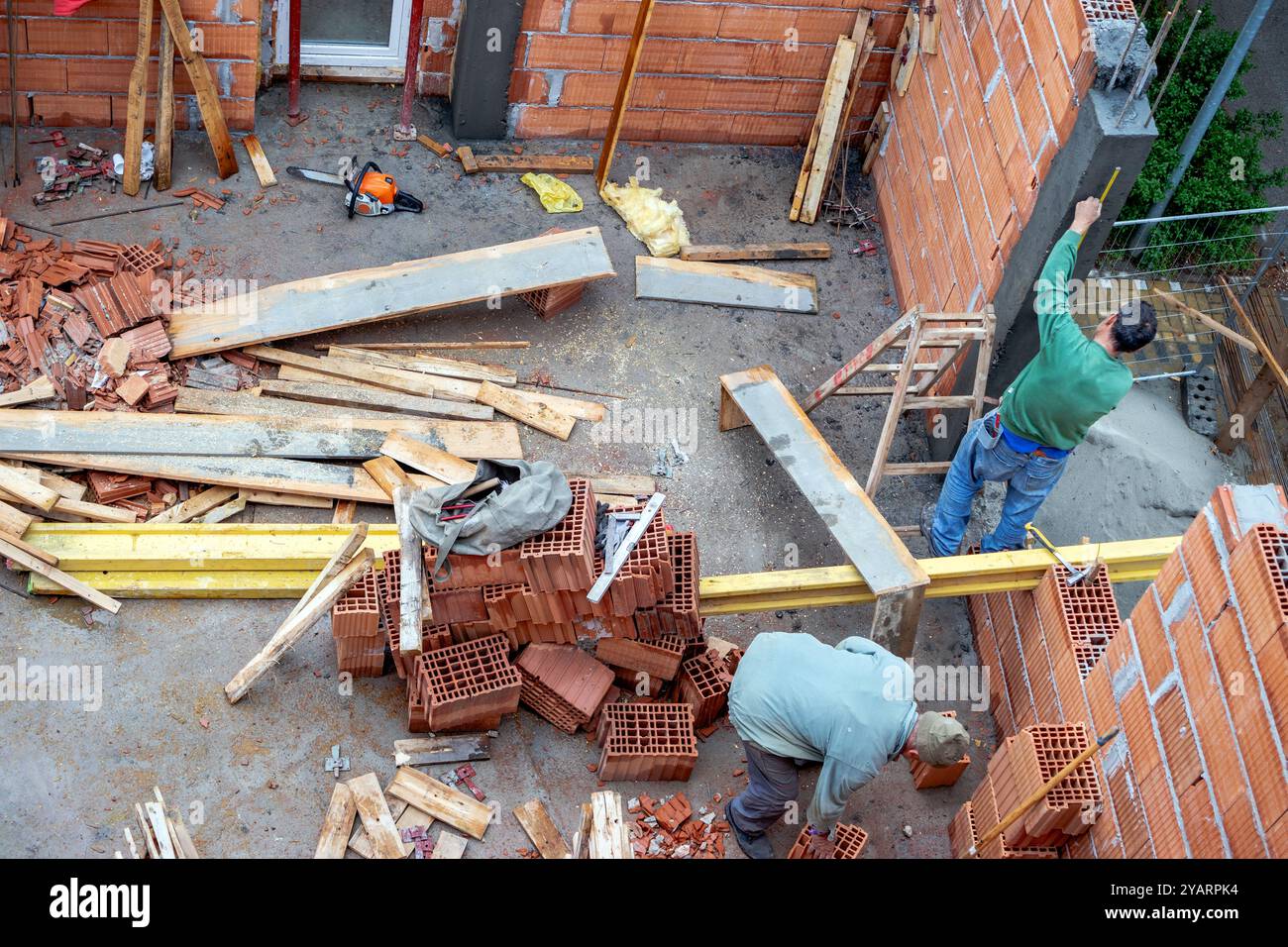 Construction workers are checking the measurement of the wall of the ...