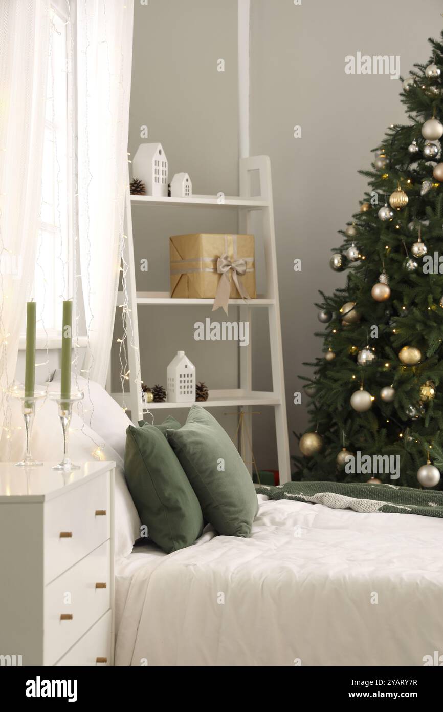 Interior of festive bedroom with cozy bed and Christmas tree Stock ...