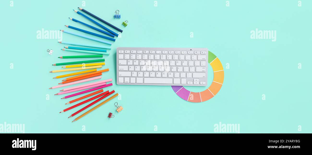 Workplace of graphic designer with PC keyboard, color charts and ...