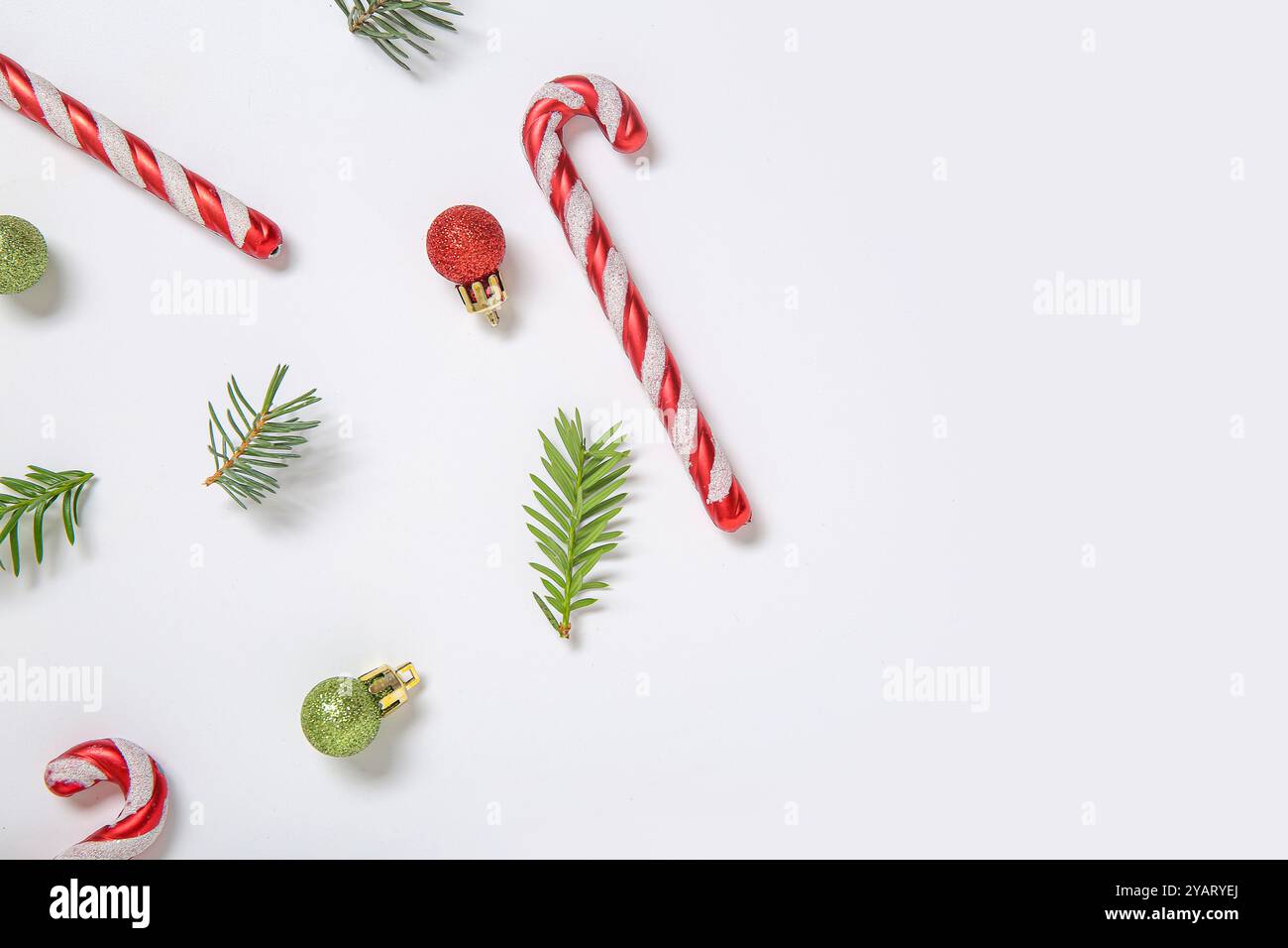 Fir branches with candy canes and Christmas balls on white background Stock Photo - Alamy
