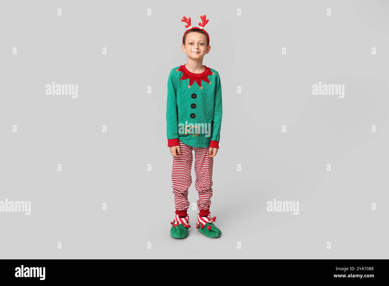 Cute little boy dressed as elf on grey background Stock Photo - Alamy