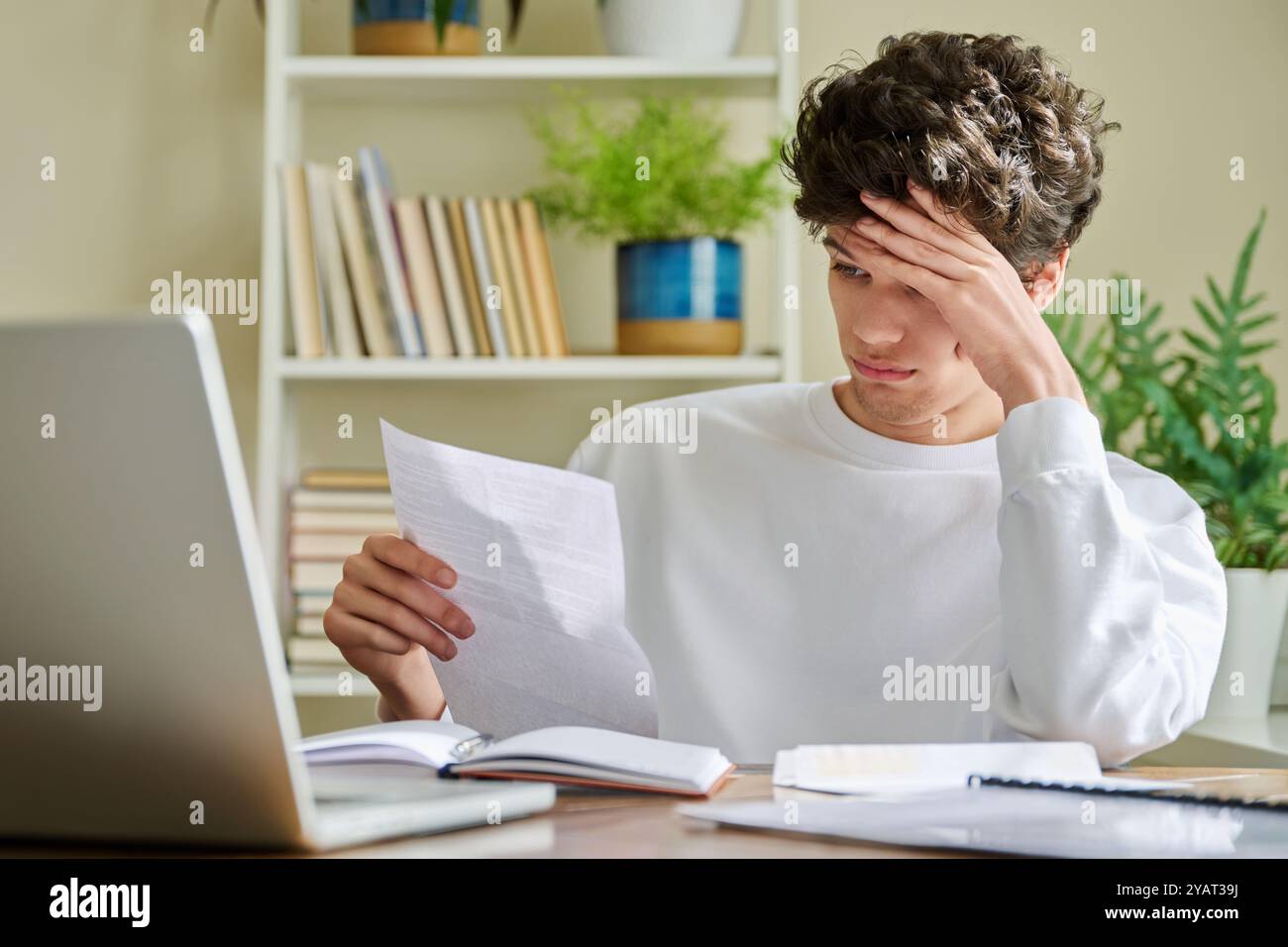 Serious young guy reading letter, paper document Stock Photo - Alamy