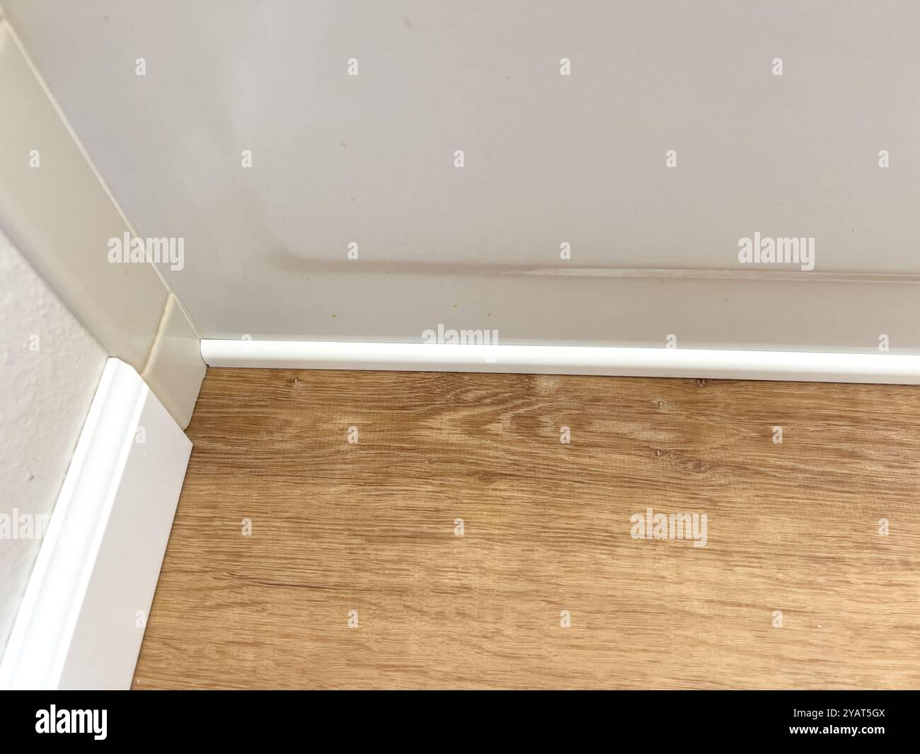 Installing White Vinyl Baseboards and Trim Pieces in a Room Under ...