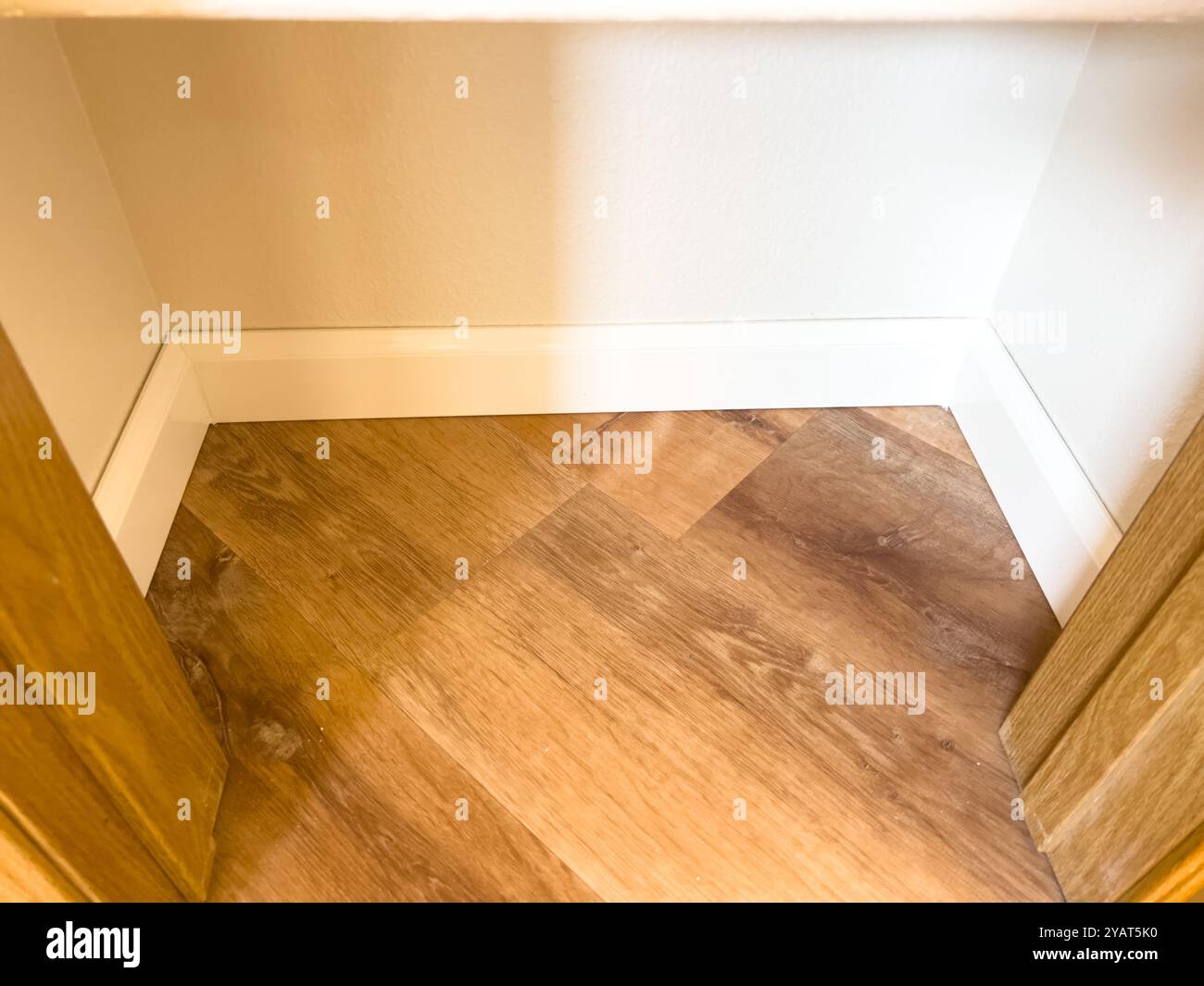 Installing White Vinyl Baseboards and Trim Pieces in a Room Under ...