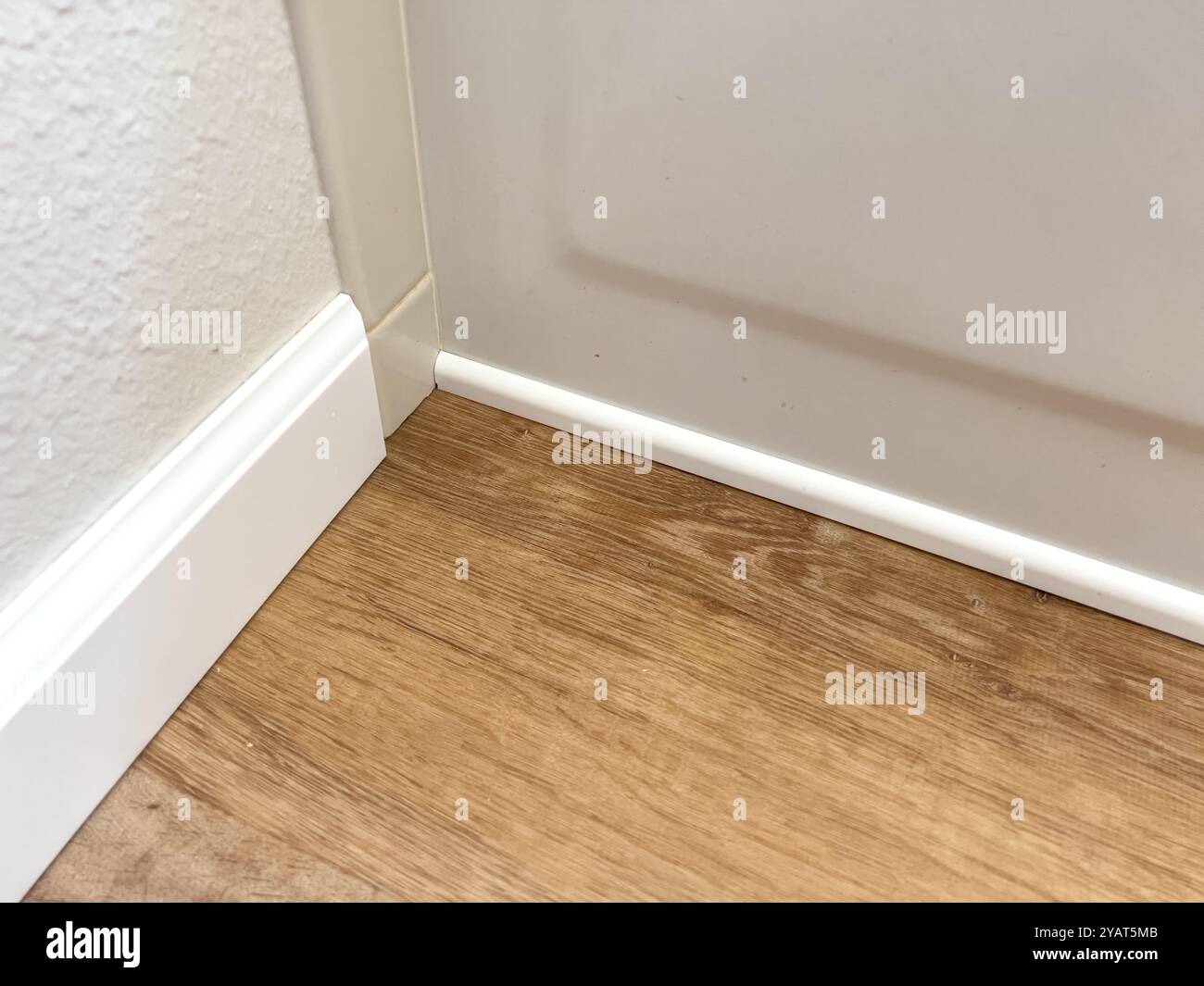 Installing White Vinyl Baseboards and Trim Pieces in a Room Under ...