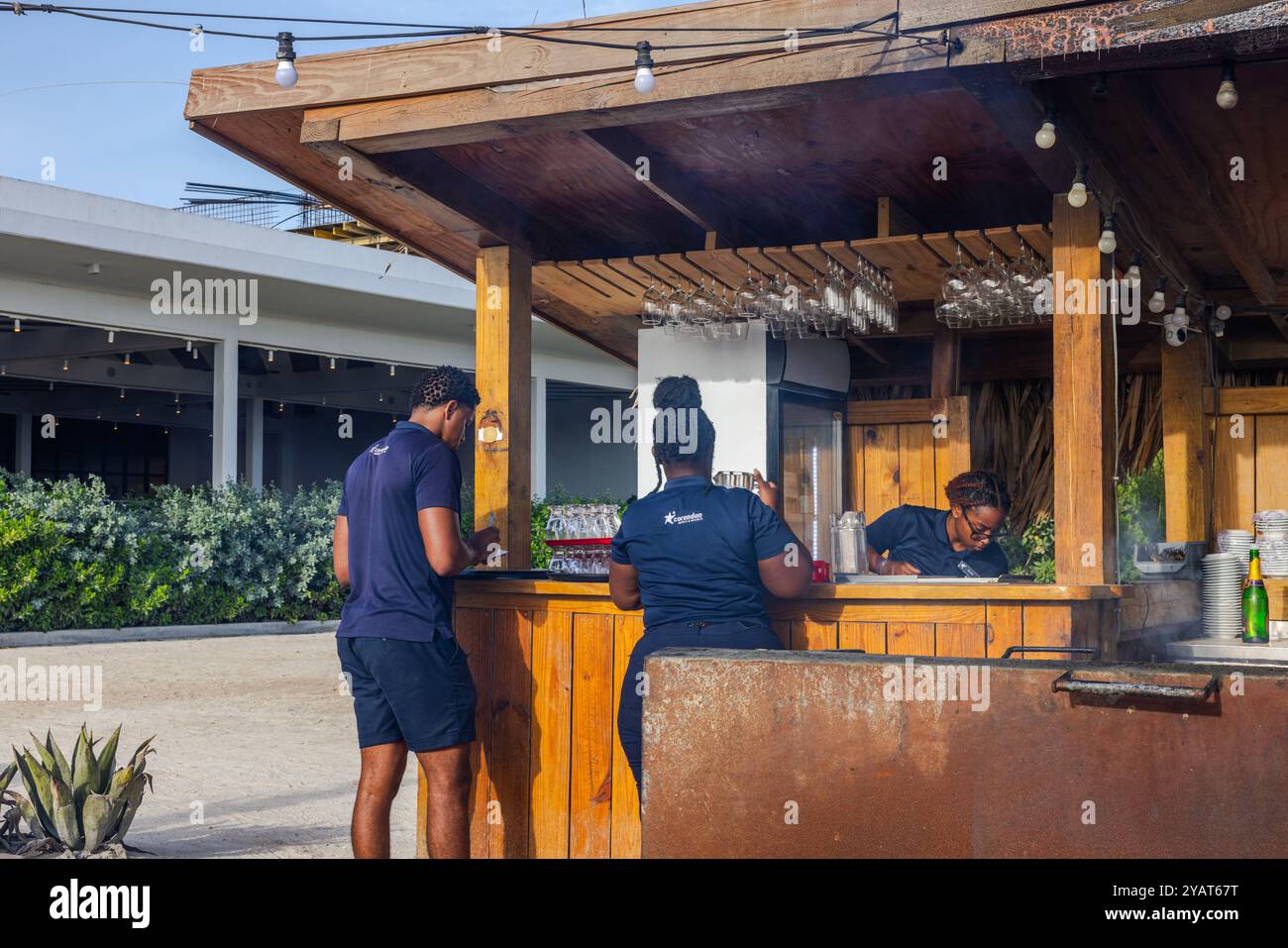 Workers preparing drinks at outdoor wooden bar hotel on island of ...