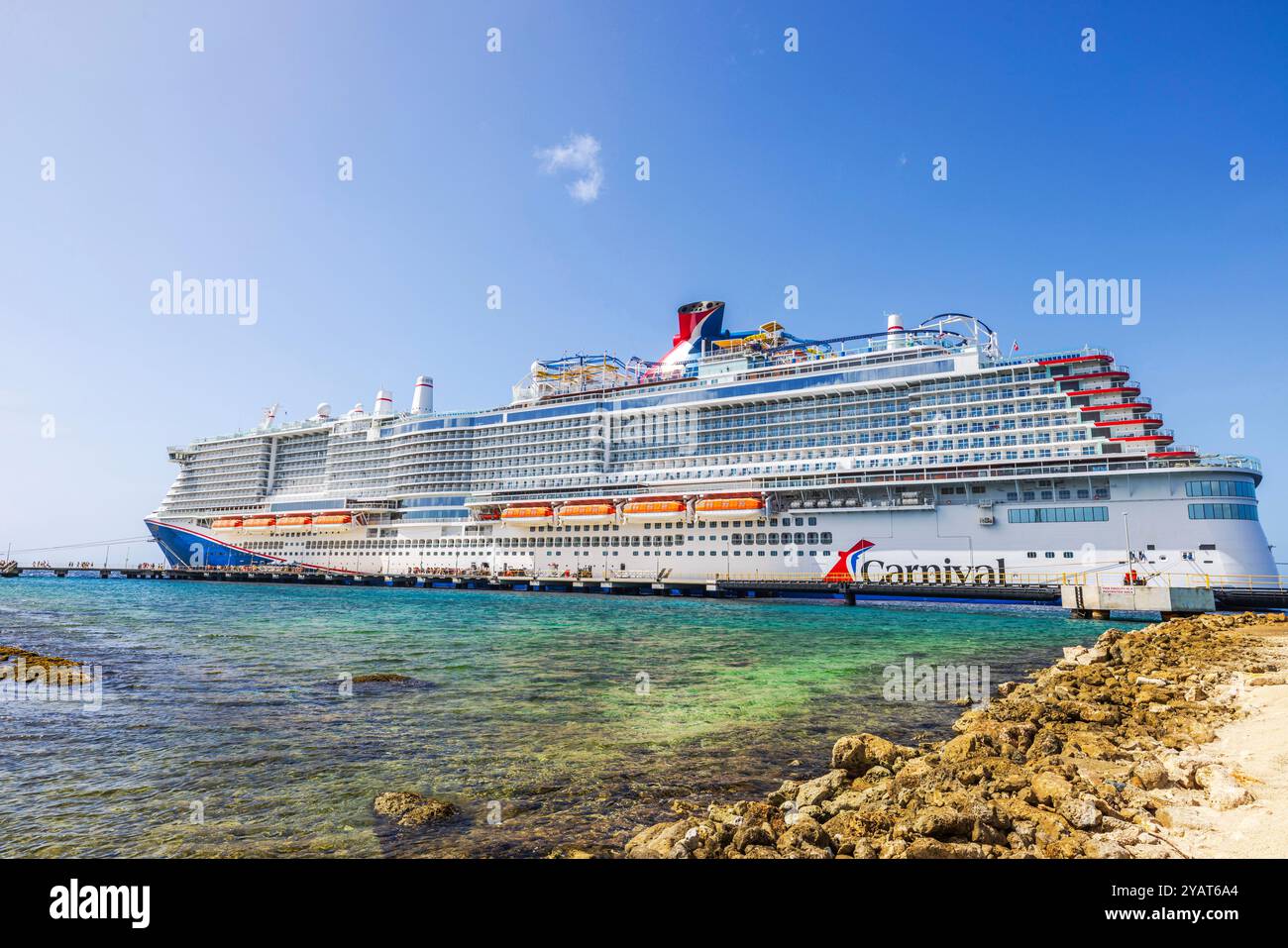 Large Carnival cruise ship docked at pier in Caribbean sea with clear ...