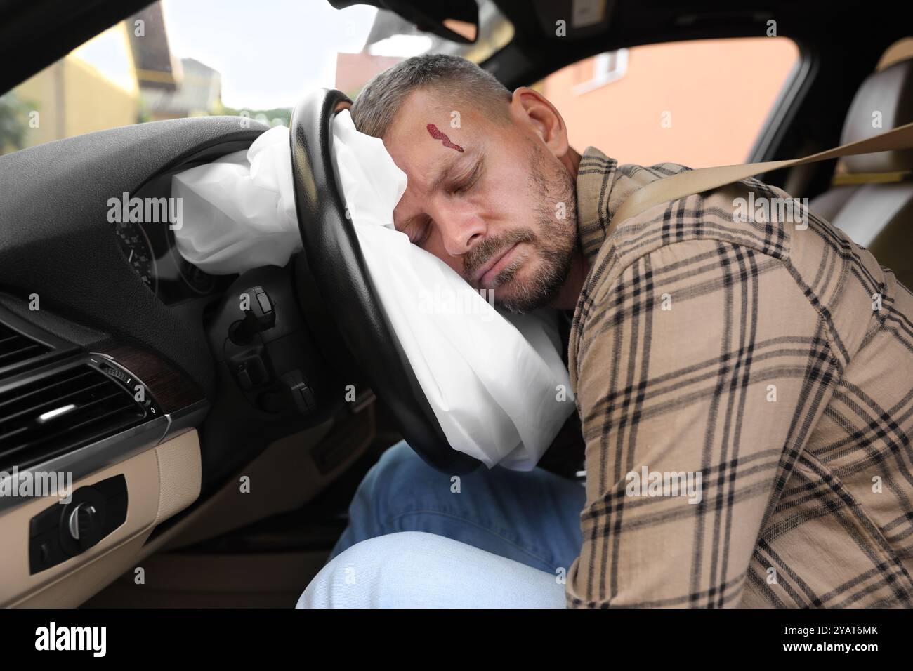 Unconscious man with head injury on airbag in automobile after car ...