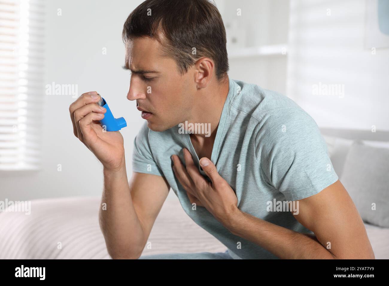 Man using inhaler at home. Asthma treatment Stock Photo - Alamy