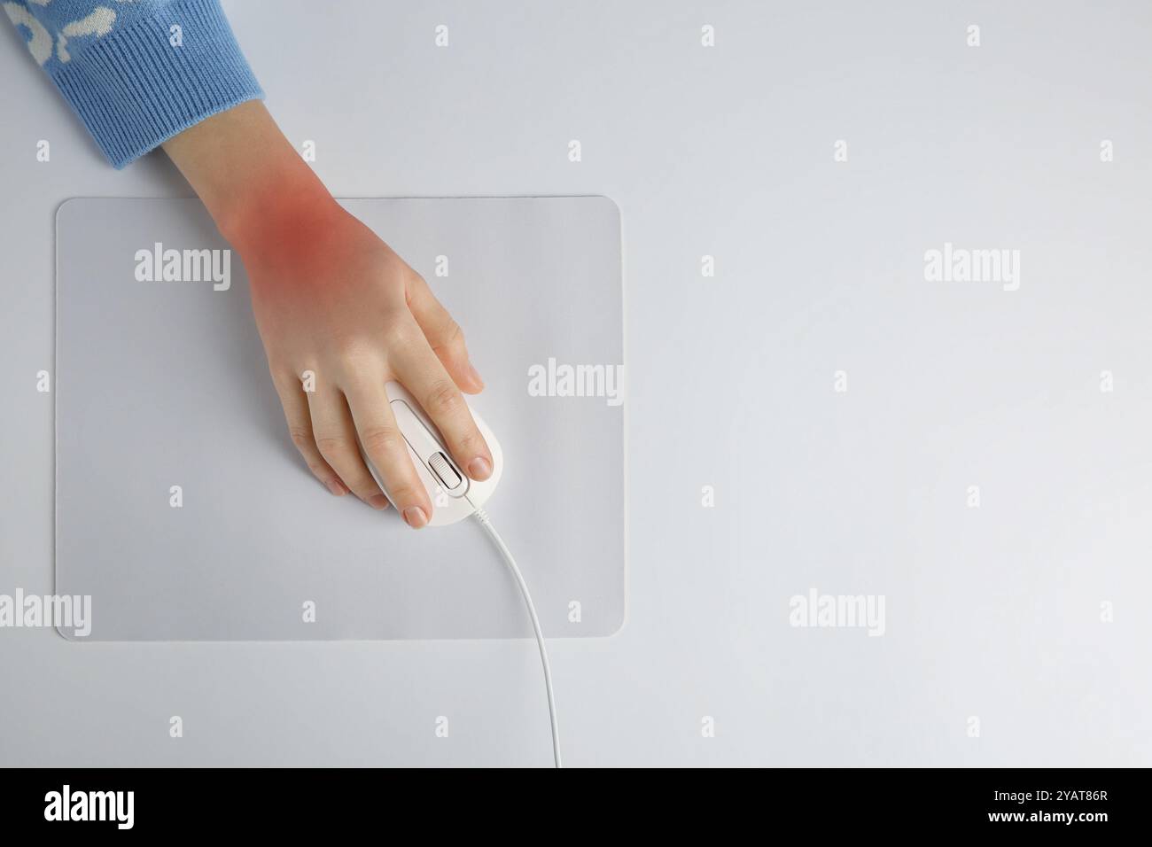 Woman suffering from pain in wrist while using computer mouse at white ...