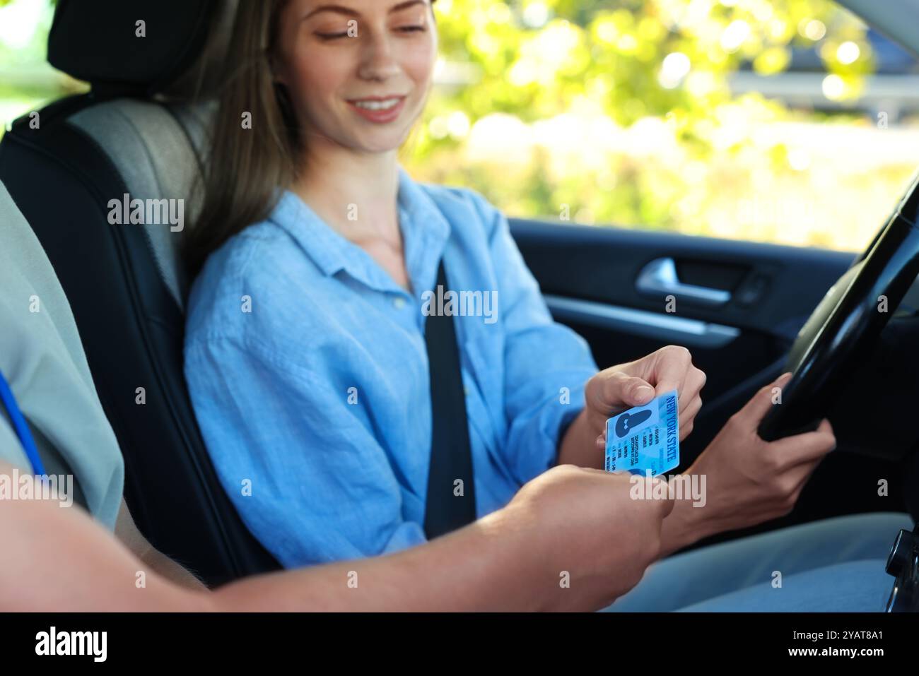 Driving school. Examiner giving driving license to student after exam ...