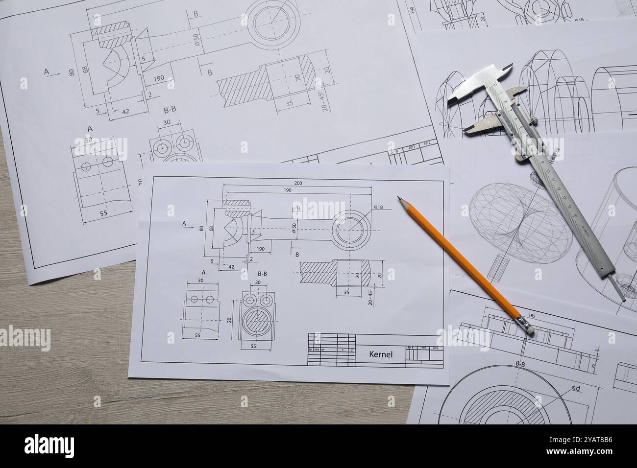 Different engineering drawings, vernier caliper and pencil on wooden ...
