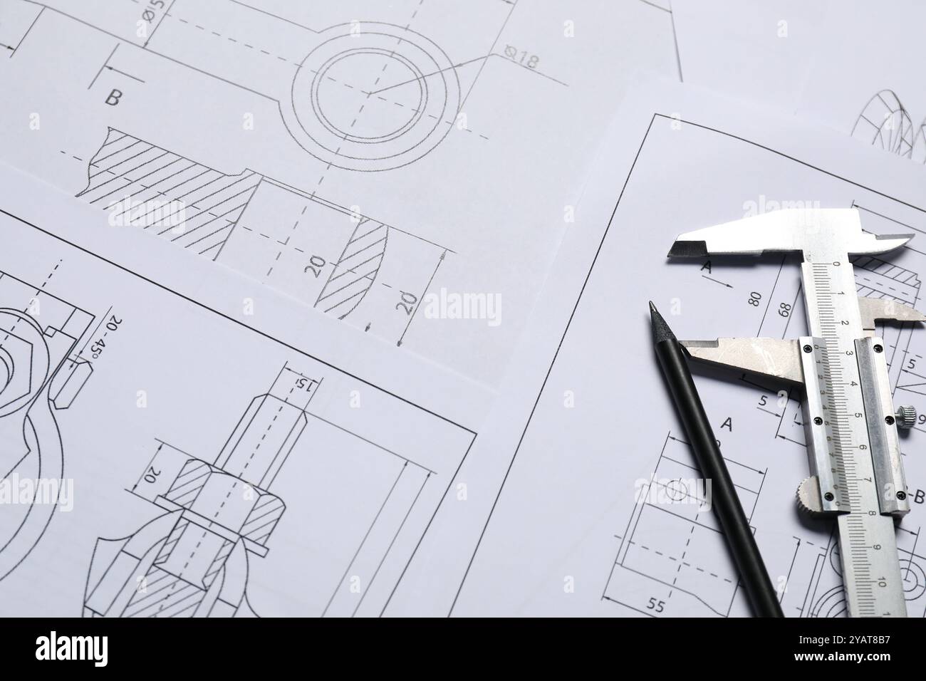 Different engineering drawings, vernier caliper and pencil, above view ...