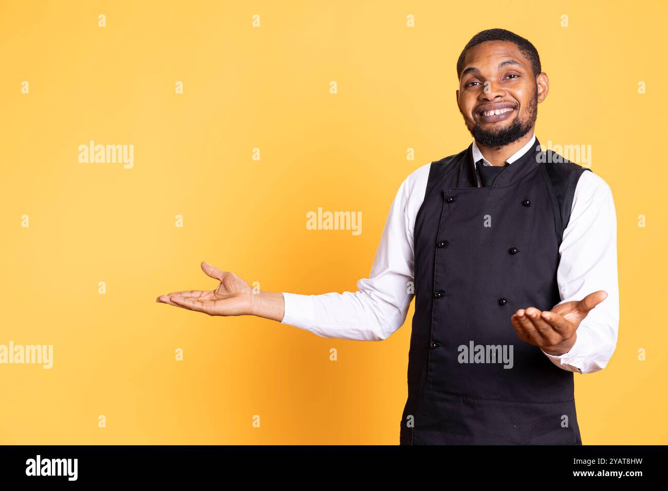 African american waiter points at something to his left or right ...