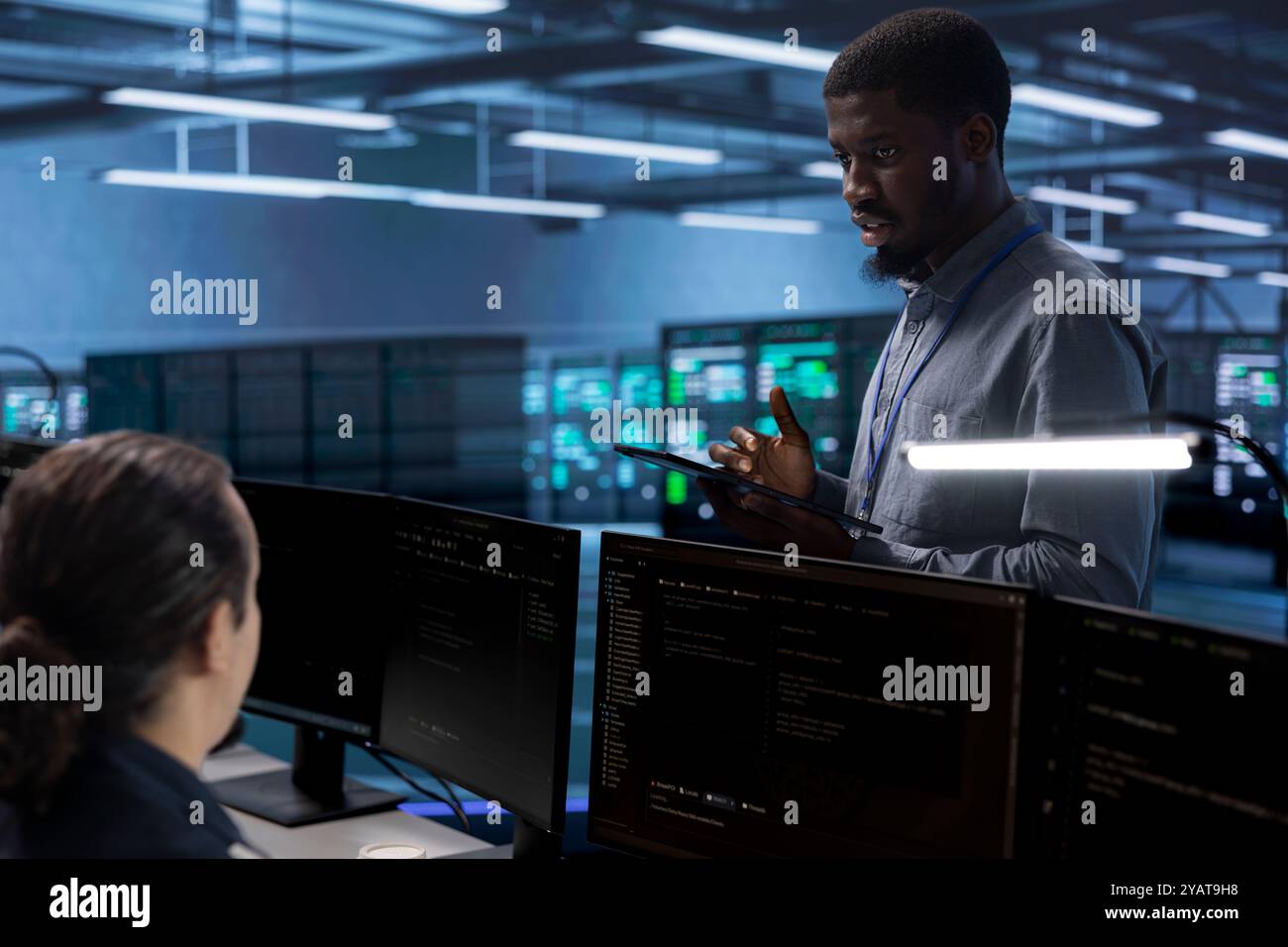 African American Man In Data Center Using Diagnostic Tools And System Monitoring Software To