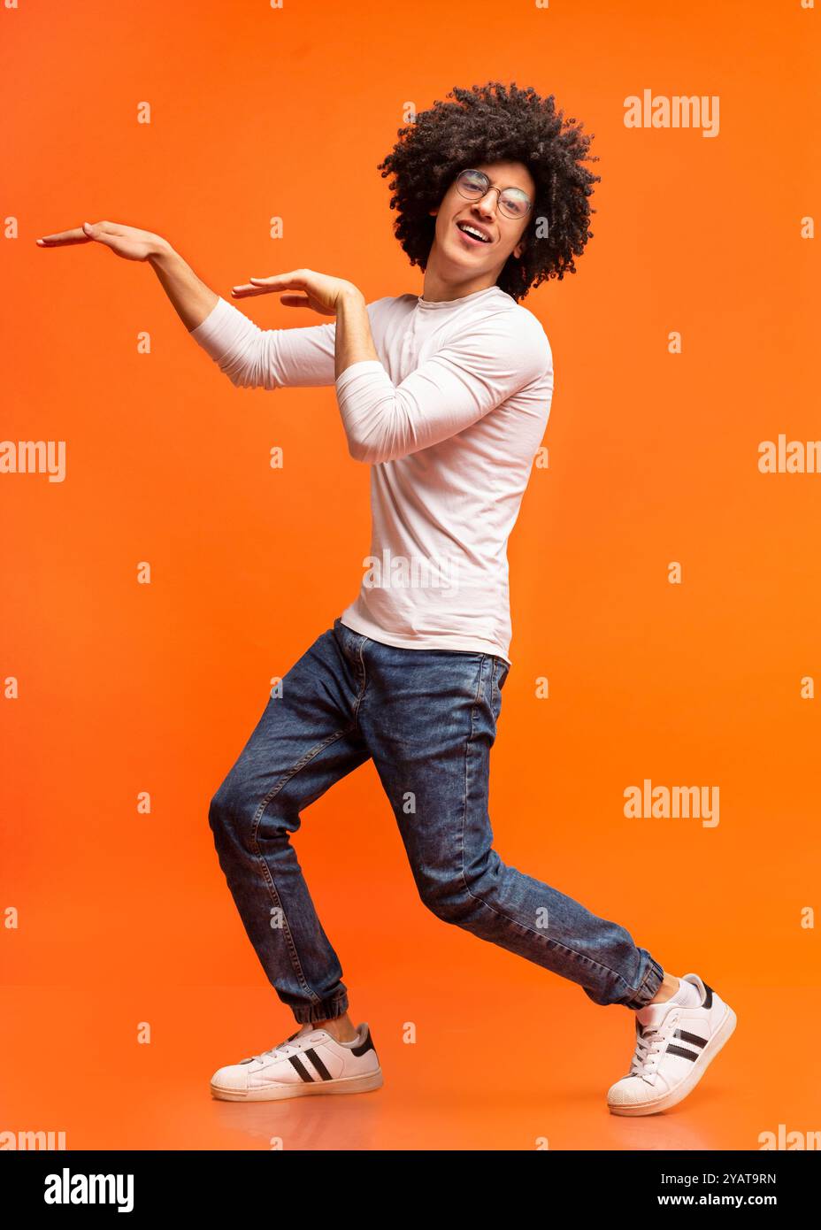 Funny black guy dancing in egypt style on orange background Stock Photo ...