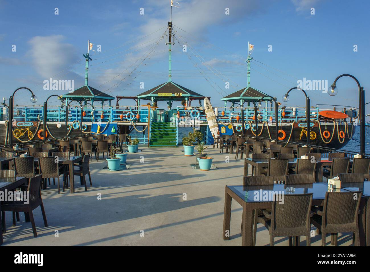 A colorful boat-shaped restaurant overlooks the sparkling water, with ...
