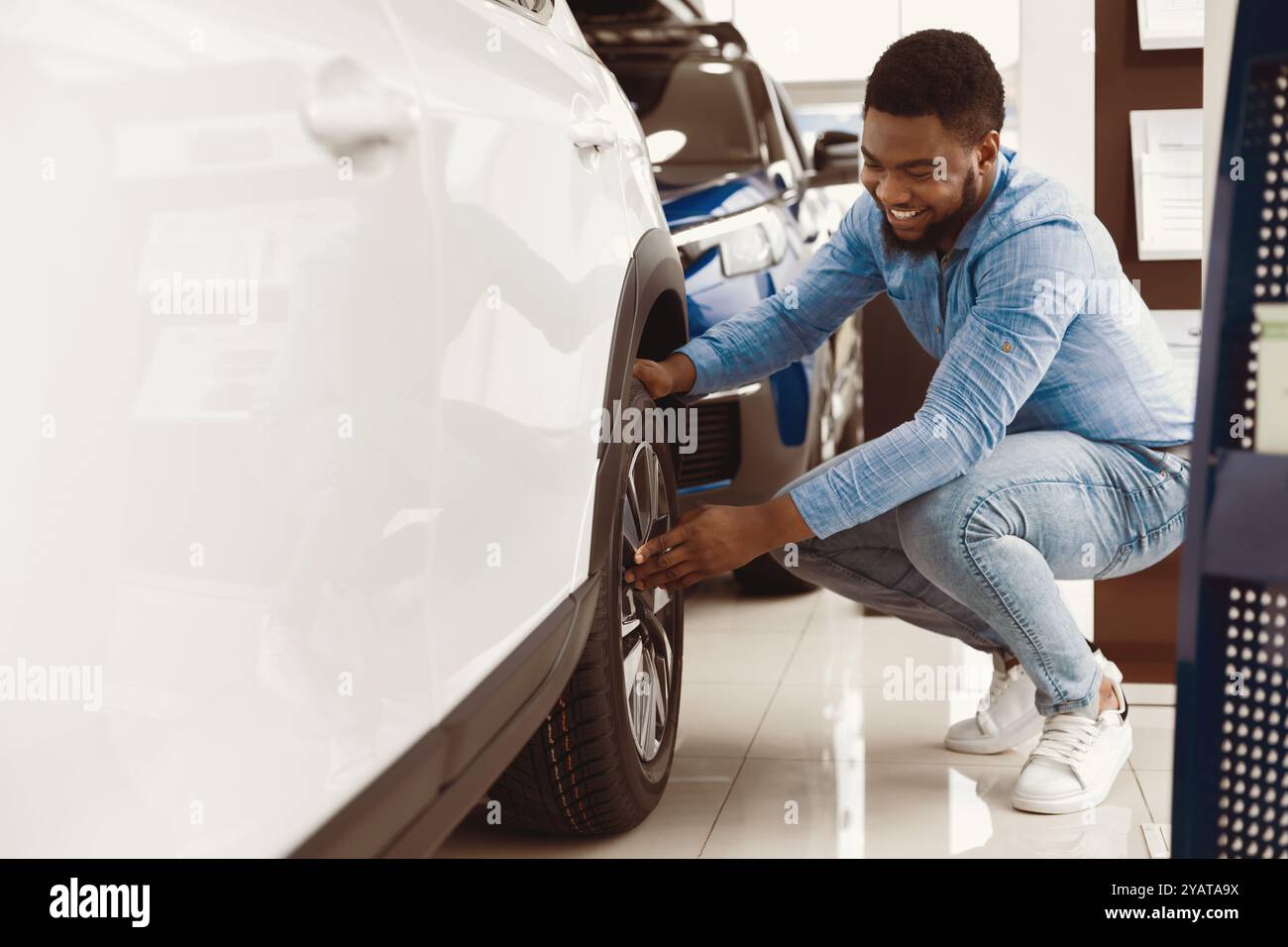 Afro Guy Checking Wheels Buying Auto In Dealership Store Stock Photo ...