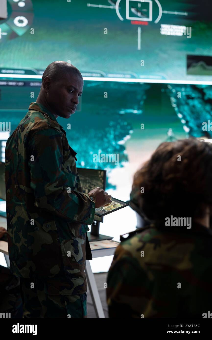 Infantry unit trooper studying the reconnaissance activity in control center, soldiers work with ...