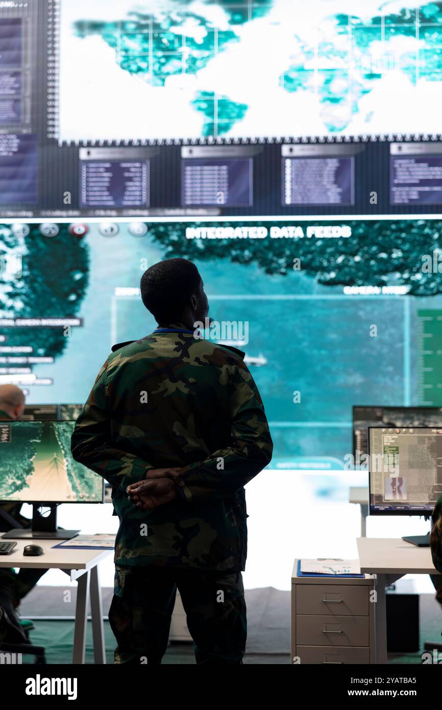 Infantry unit recruit analyzing important battlefield data on big screen, gathering information ...