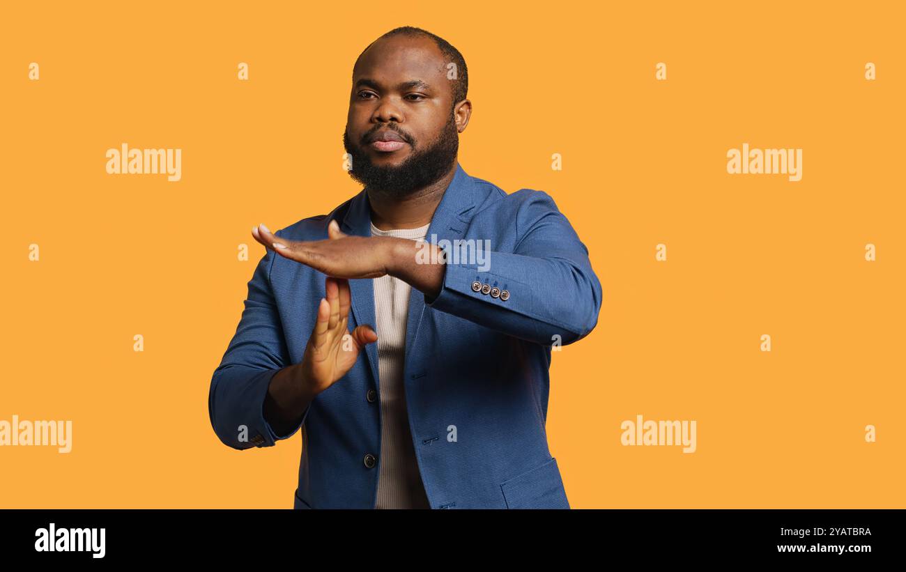 Portrait of assertive BIPOC man asking for timeout, doing hand gestures ...