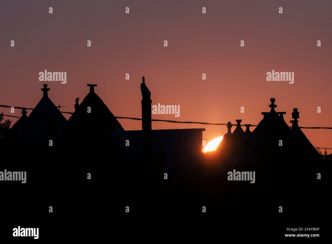 The sun sets behind the roofs of the Trulli at Alberobello Stock Photo ...