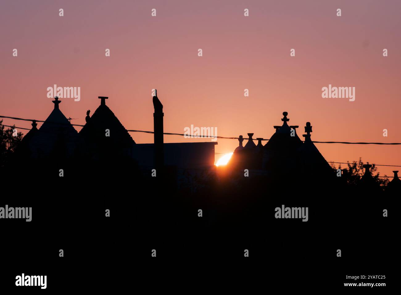 The sun sets behind the roofs of the Trulli at Alberobello Stock Photo ...