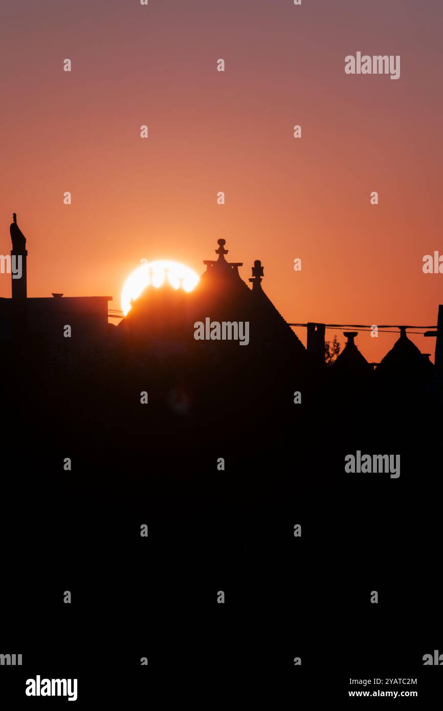 The sun sets behind the roofs of the Trulli at Alberobello Stock Photo ...
