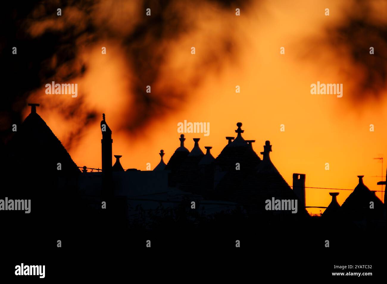 The sun sets behind the roofs of the Trulli at Alberobello Stock Photo ...