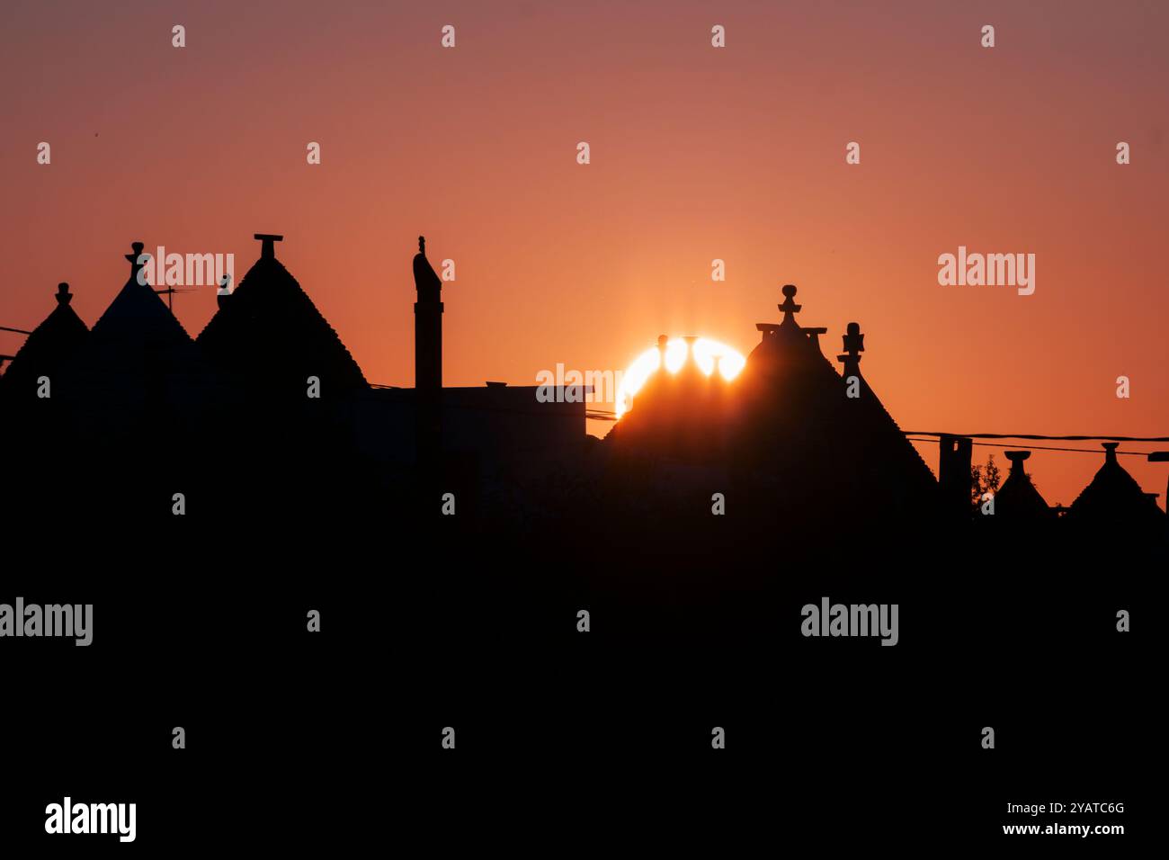 The sun sets behind the roofs of the Trulli at Alberobello Stock Photo ...