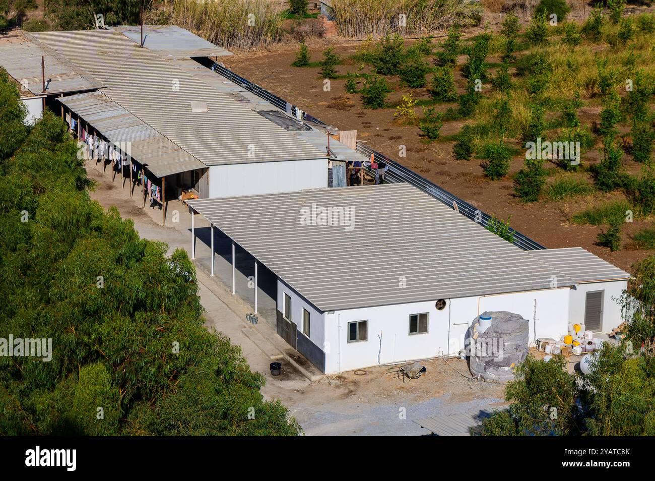A modest rural building with an extended roof displays clothes drying ...