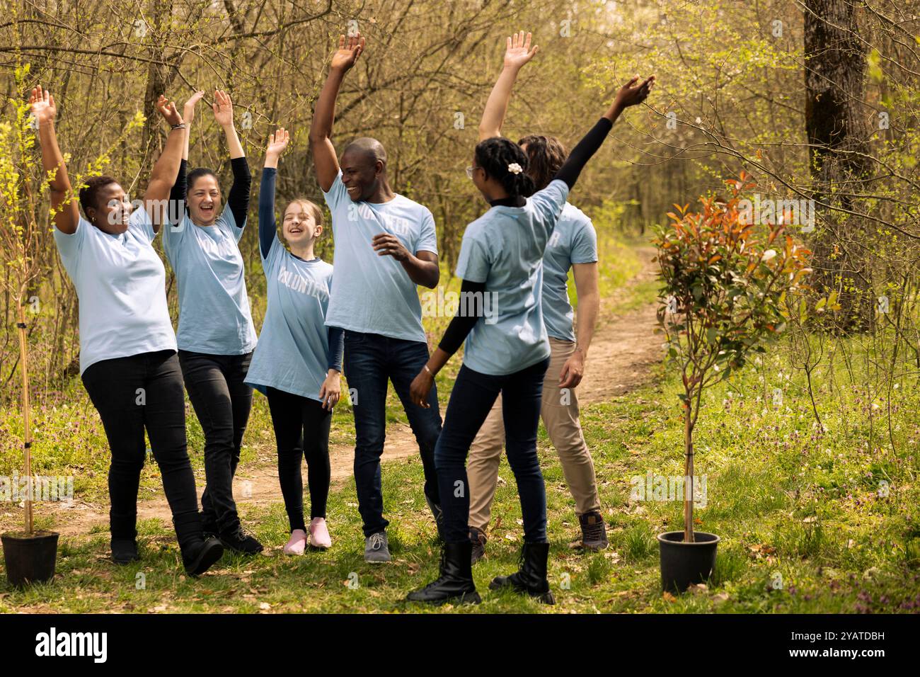 Diverse group of volunteers connecting hands after a successful ecology ...
