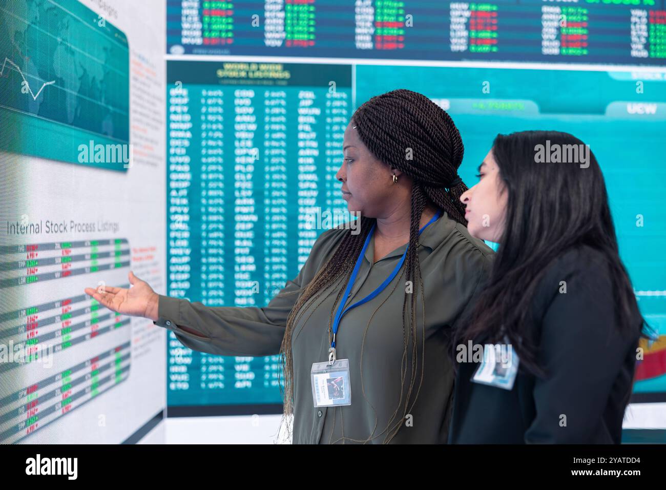 Diverse team of employees examine infographics on a big screen to ...
