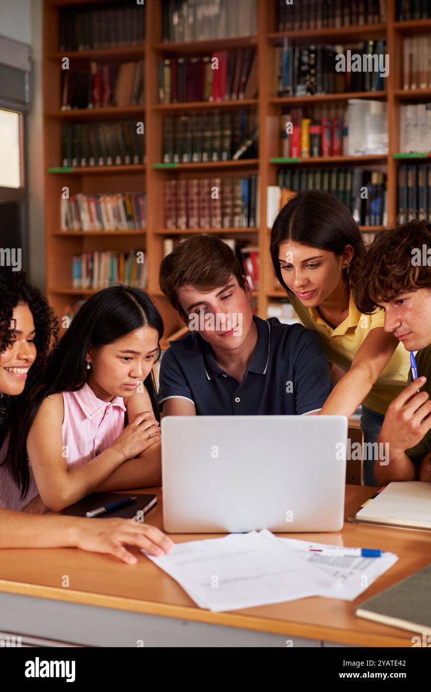 Group of students at library gathering together to do a school project ...