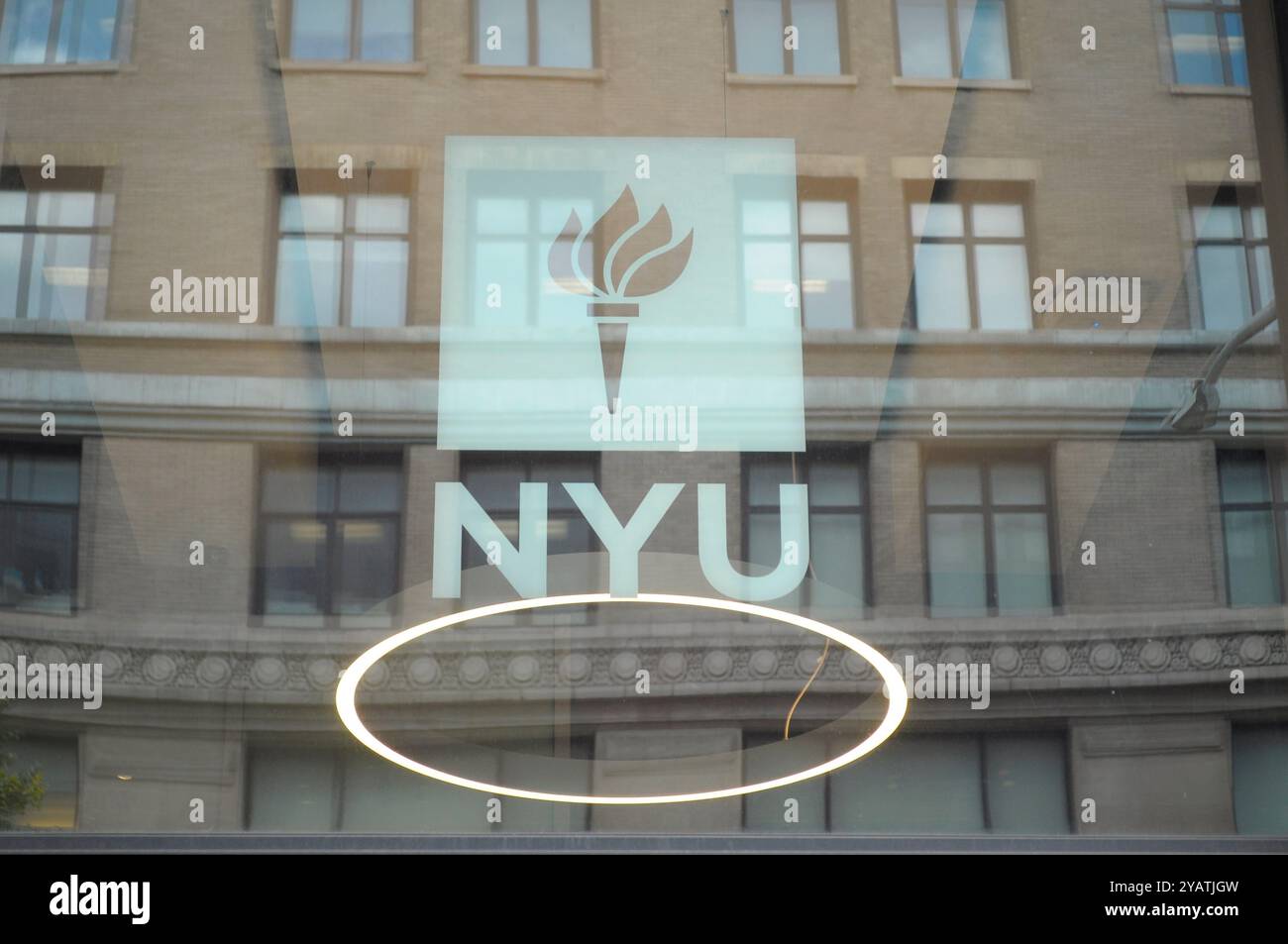 A New York University logo is seen on the window of an NYU building in ...