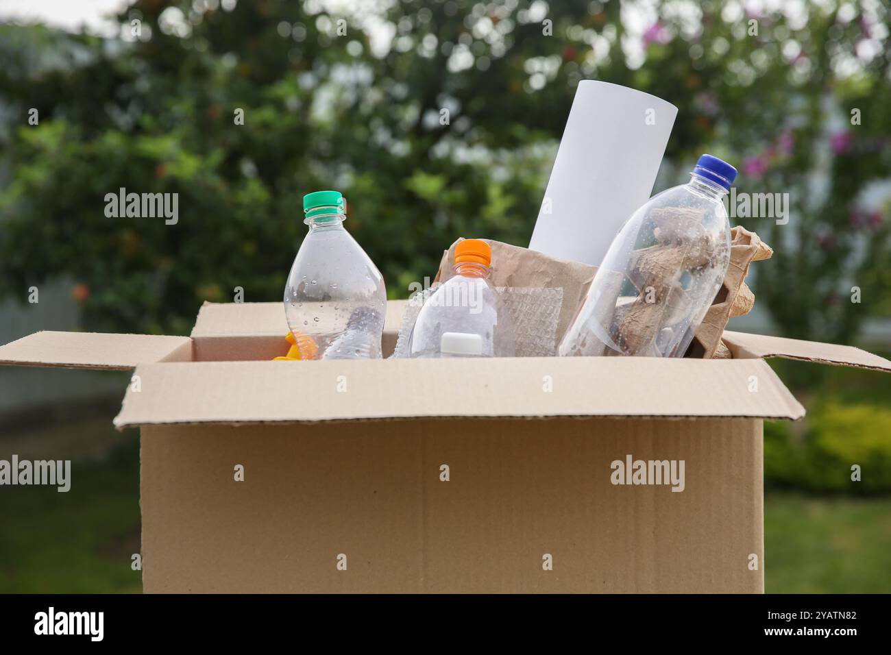 Recycling. Different garbage in cardboard box outdoors Stock Photo - Alamy