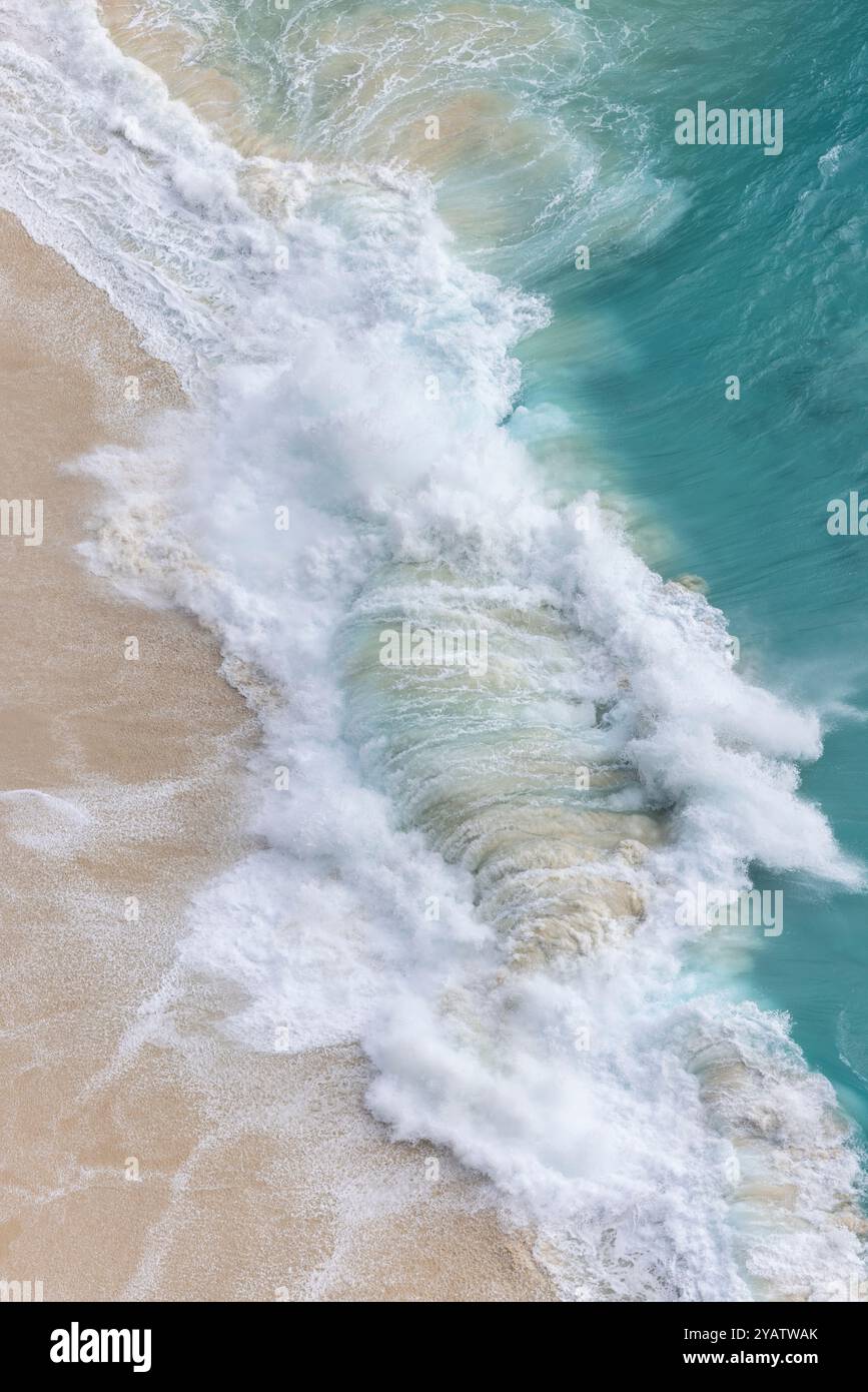 From above, turquoise waves gently crash onto the soft sands of ...