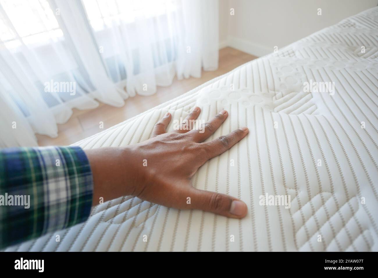 Hand touching and pressing orthopedic mattress on bed Stock Photo - Alamy