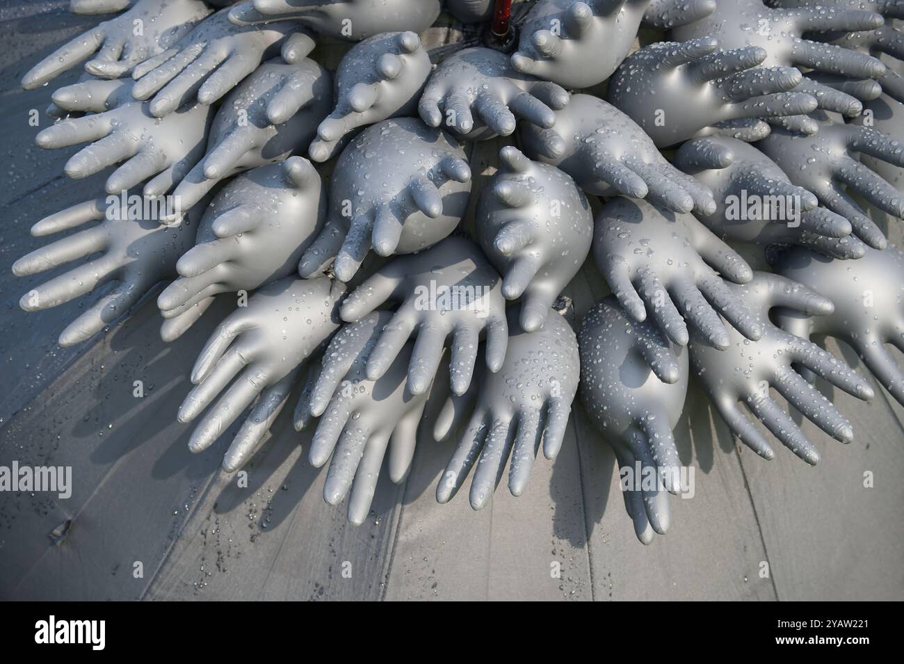 Inflated rubber gloves covered in water droplets forms an abstract ...