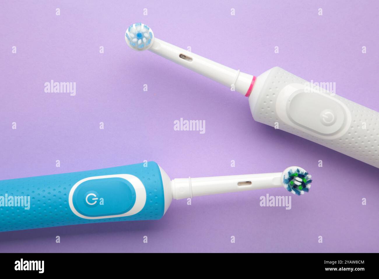 Two Modern electric toothbrushes on purple background. Top view. Teeth ...
