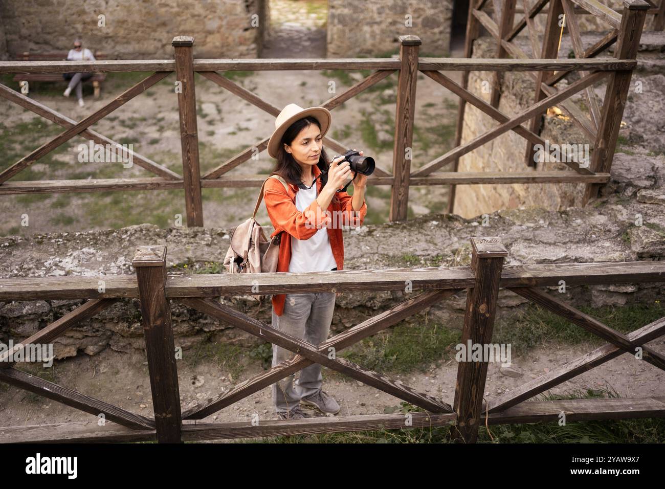 Female traveler carefully takes photos while exploring ancient fortress ...
