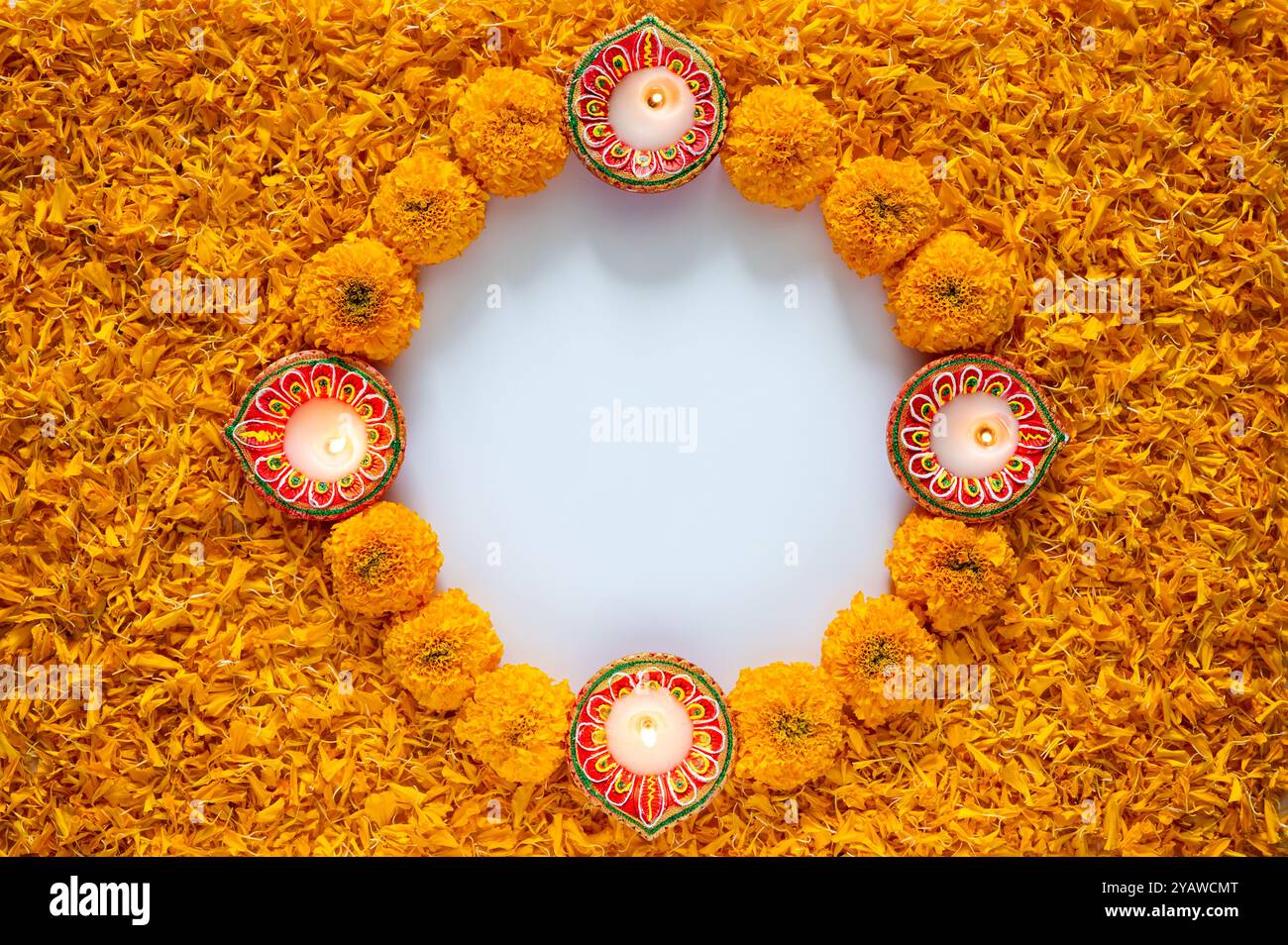 Decorative orange color marigold flowers and petals rangoli with clay ...